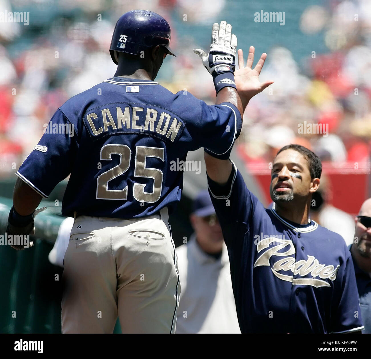 San Diego Padres' Mark Cameron, left, is greeted at the dugout steps by ...