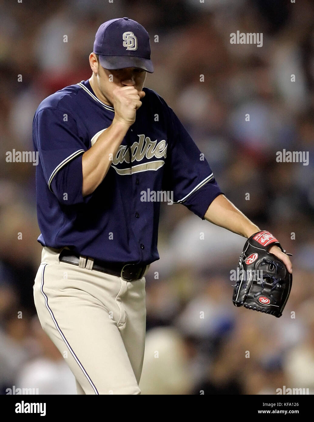 San Diego Padres pitcher Jake Peavy blows on his hand after giving up a ...
