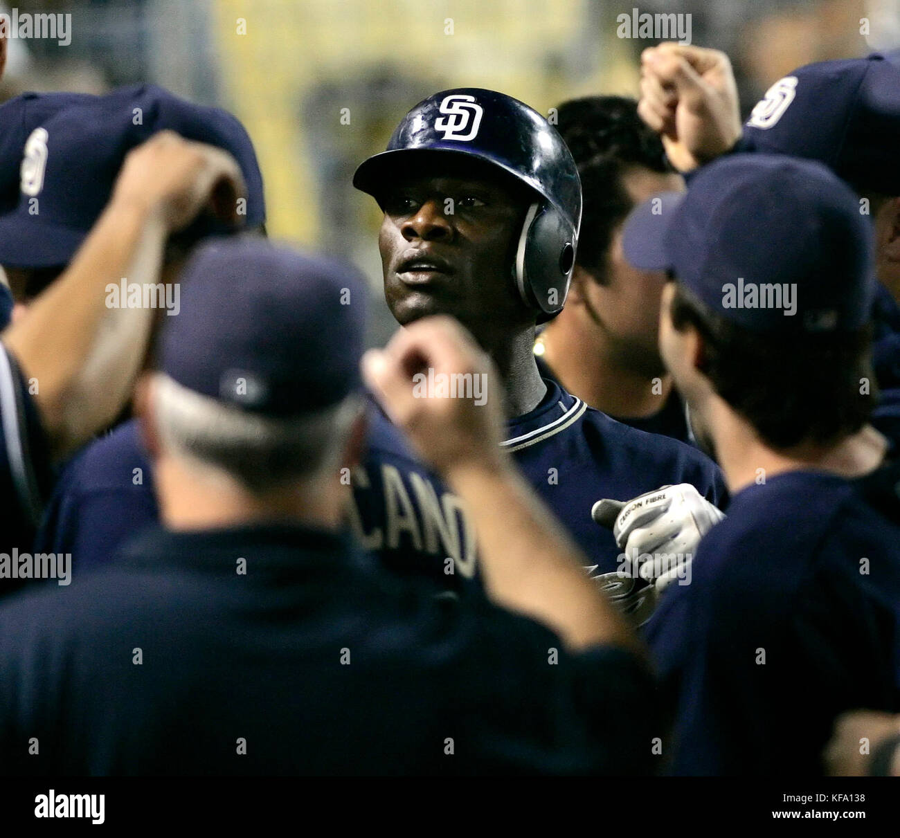 San Diego Padres' Mike Cameron, center, is greeted in the dugout by ...