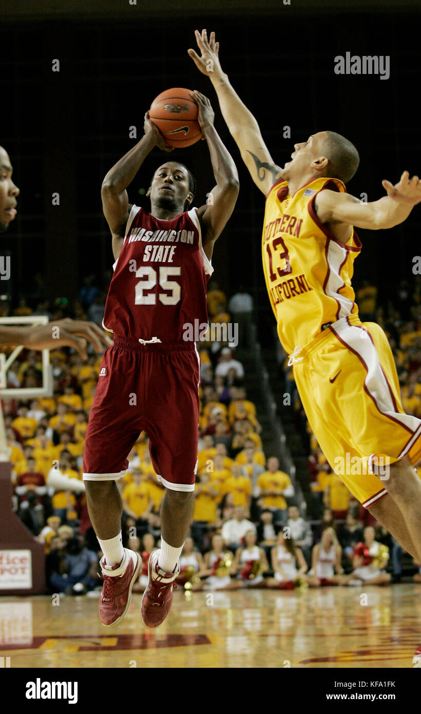 Washington State's Kyle Weaver, left, shoots past the outstretched arms ...