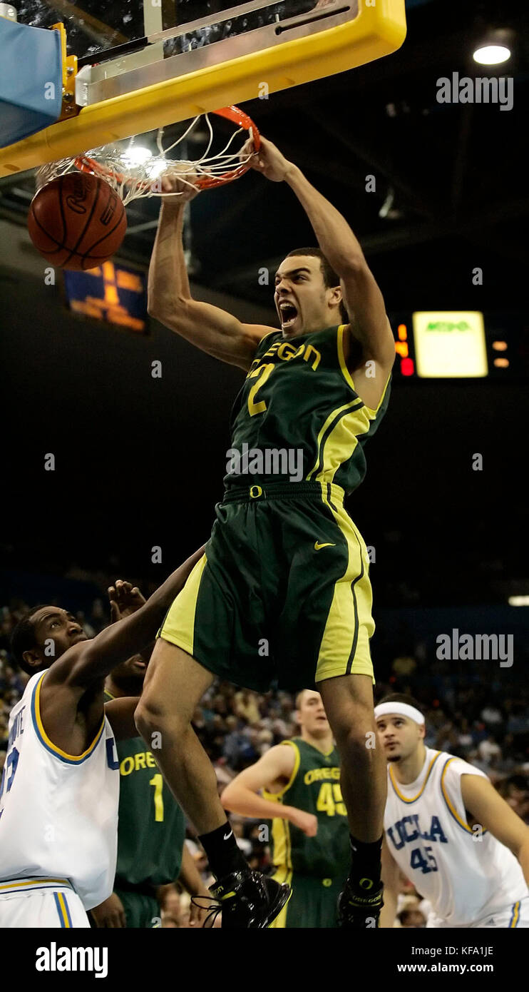Oregon's Jordan Kent, center, dunks the ball as UCLA's Luc Richard Mbah ...