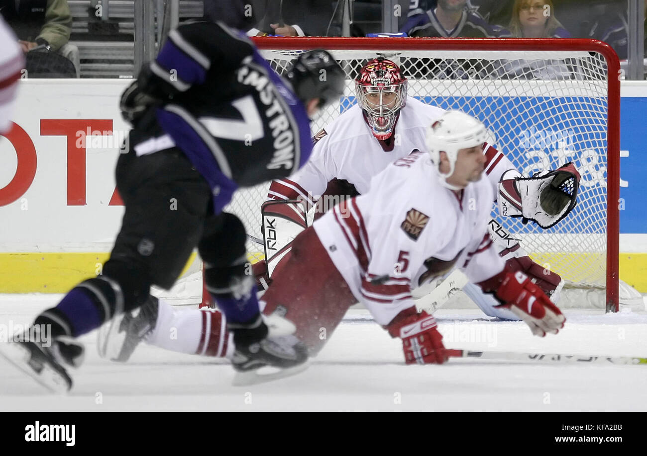 Phoenix Coyotes' goalie Curtis Joseph, background, watches a shot taken ...