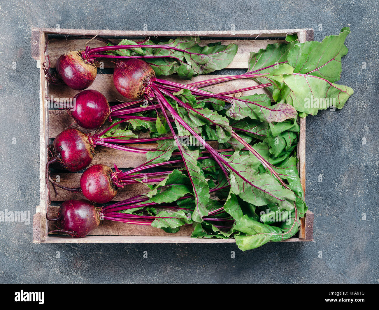 Beet, beetroot bunch in wooden box on dark stone or concrete background ...