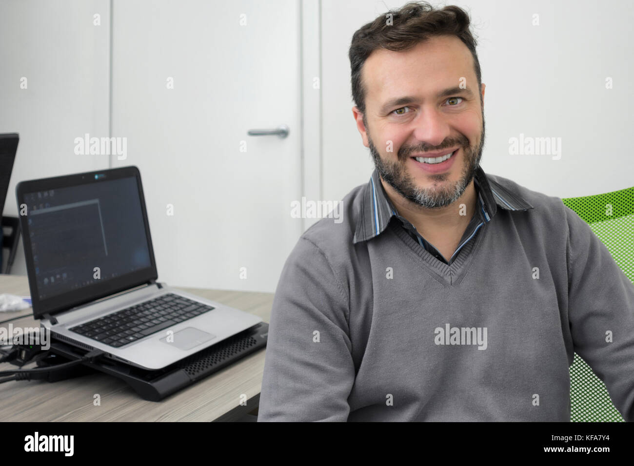 happy young business man, software developer, computer technician working in modern office of a ...