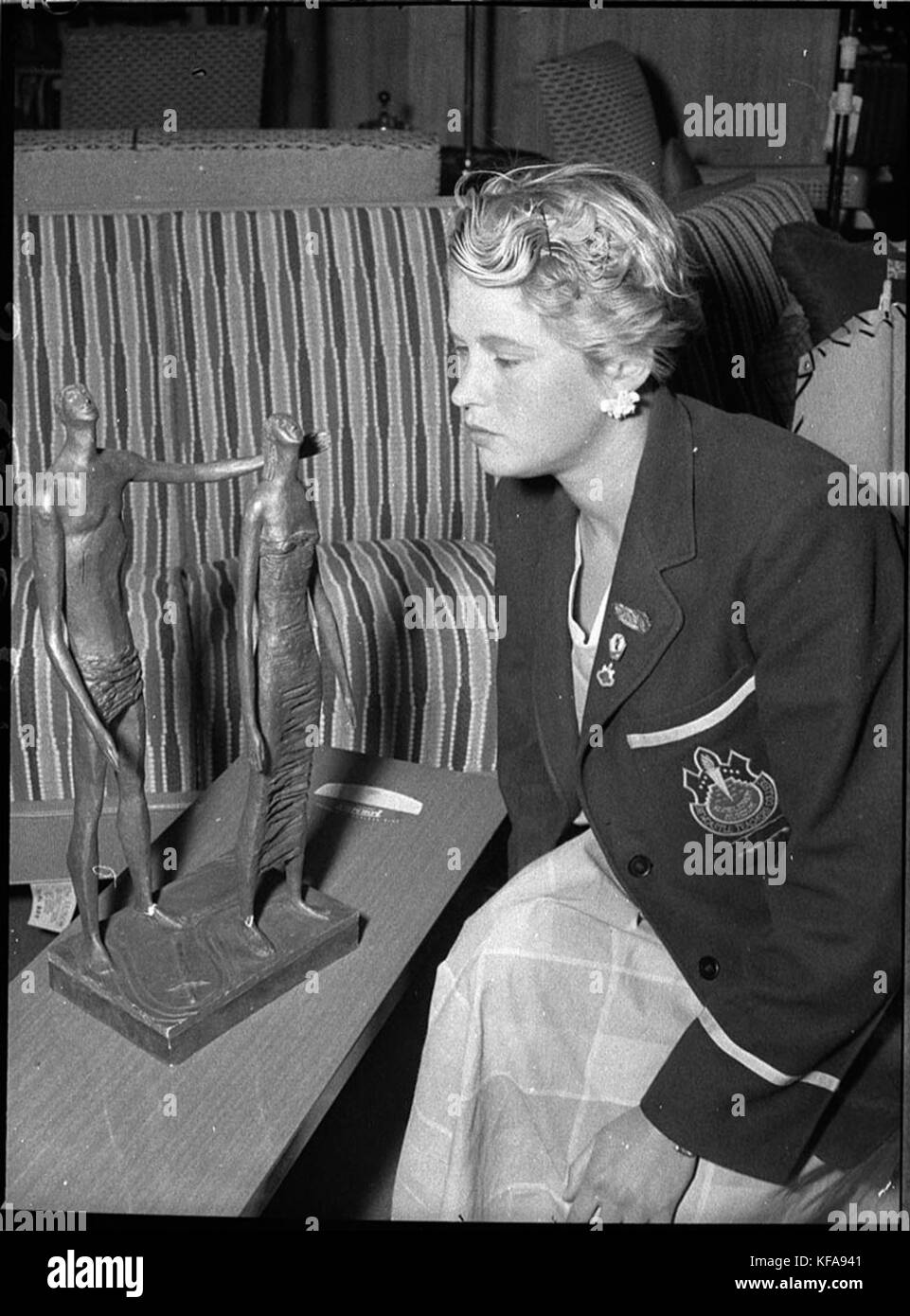 This image shows a young woman examining a model of a cultural center ...