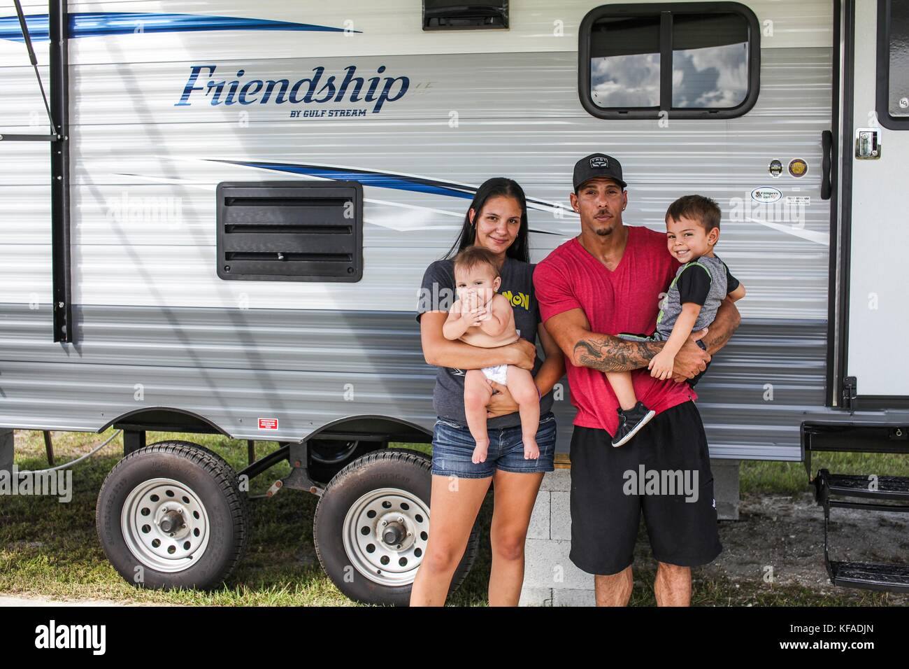 A family poses outside of their FEMA Travel Trailer during relief ...