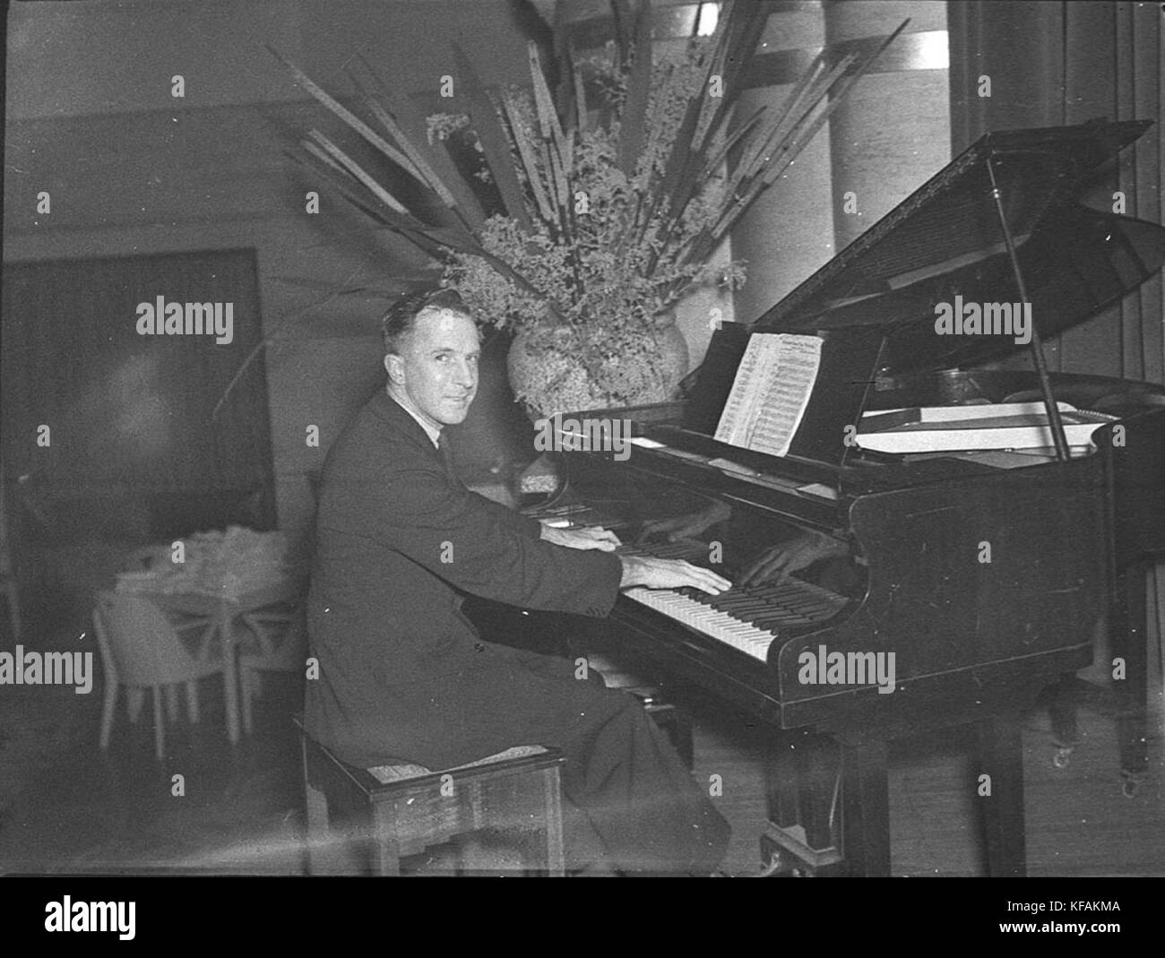 The photograph features a pianist performing in an auditorium ...