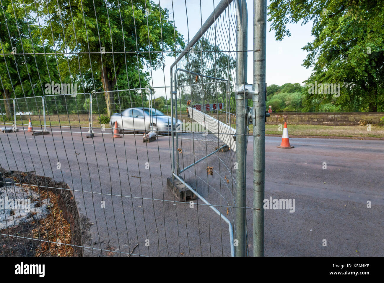 A car passing wire safety and security fencing during road works ...