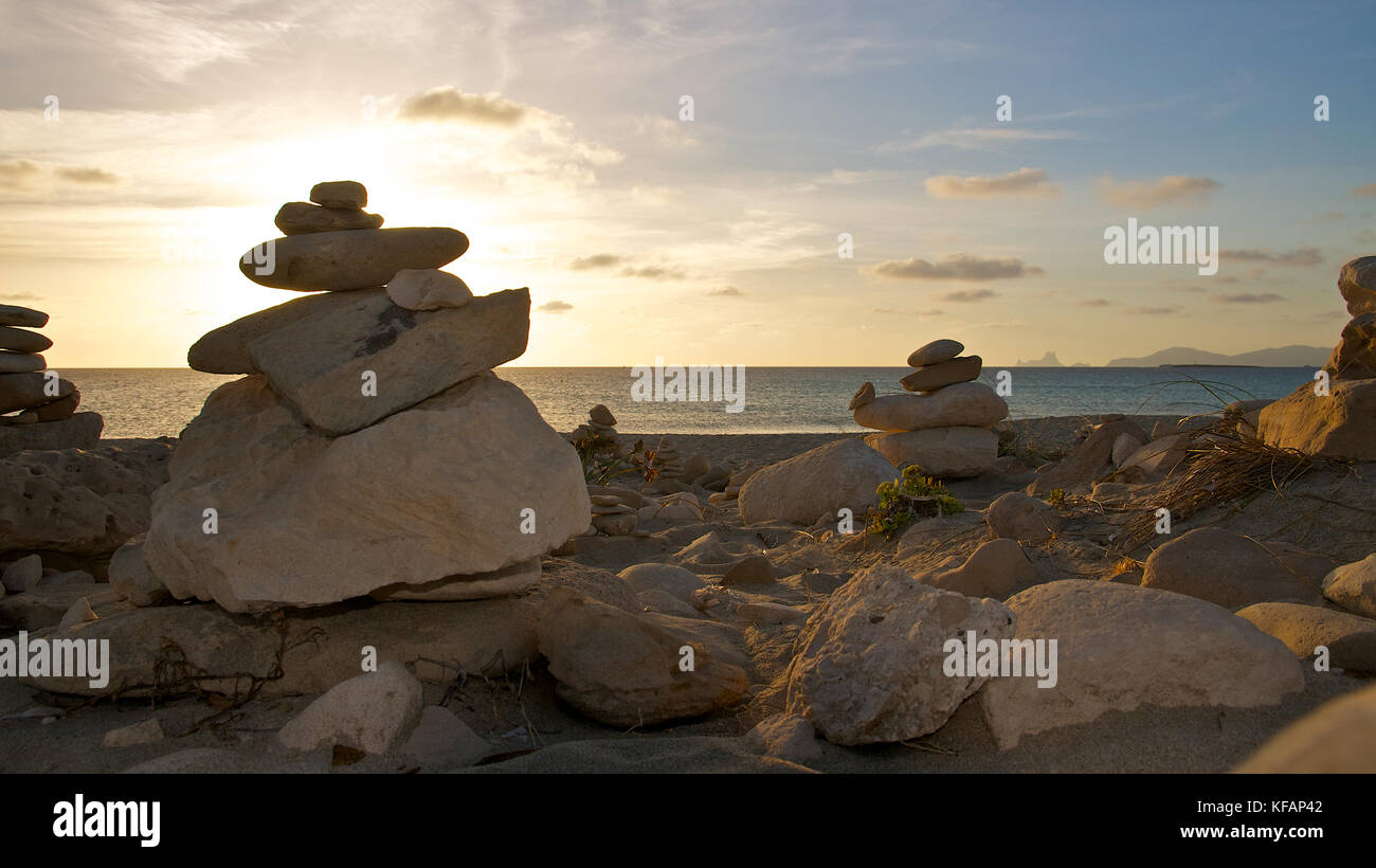 Sunset with stone piles at Ses Illetes beach with Es Vedrá and Ibiza ...