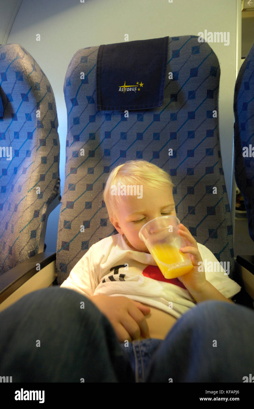 Henry sitting and drinking orange juice from a plastic cup in the ...