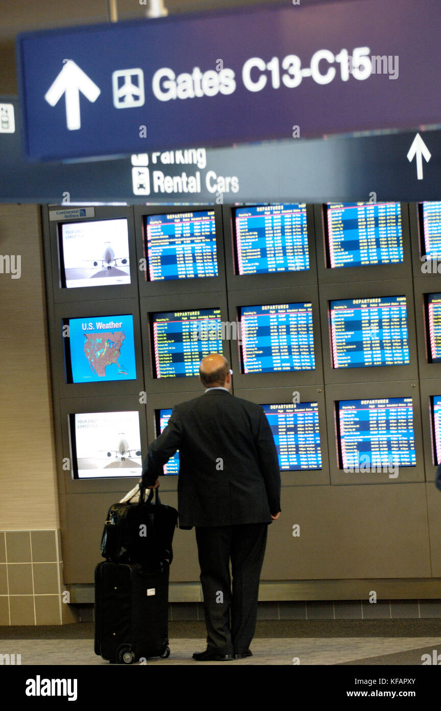 sign for Gates C13 to C15, businessman with bags looking at the flight ...