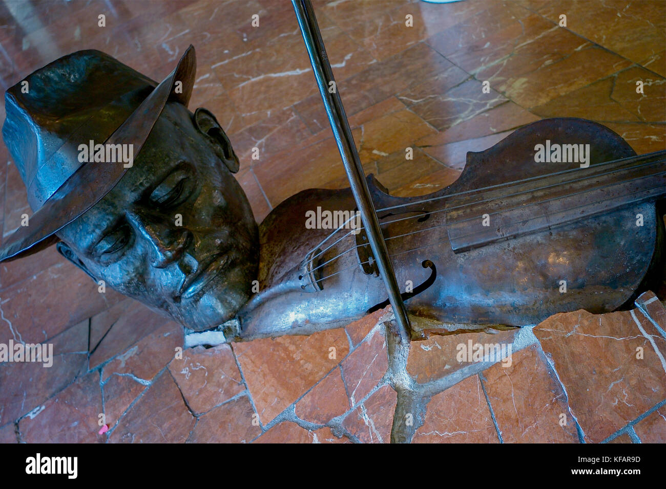 Brass sculpture of a stylized Violin player bursting off the ground at ...