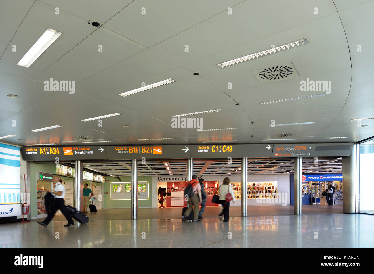 passengers walking in the terminal with sign for gates A1-A34, B11-B21 ...