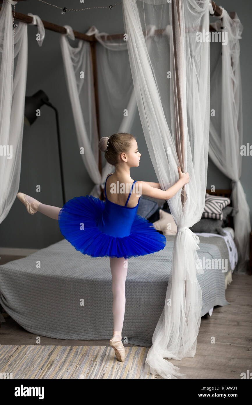 Cute little ballerina in pink ballet costume and pointe shoes is ...