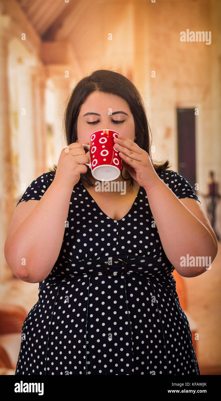 Close up of pretty fat woman in a beautiful dress, dra cup of coffe in ...