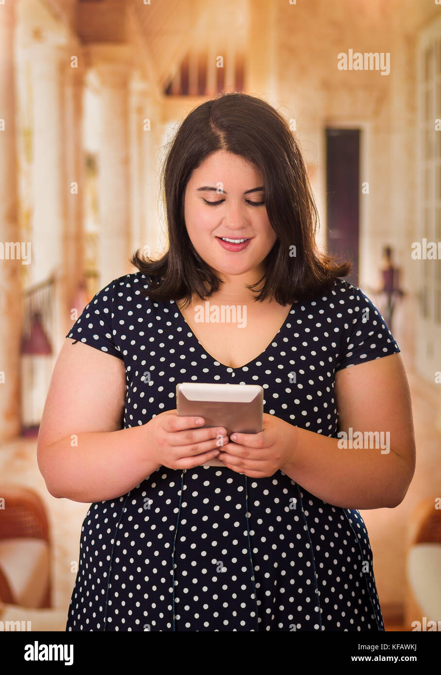Close up of beautiful fat woman in a beautiful dress using her tablet ...