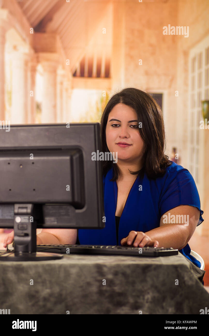 Portrait of fat woman working on laptop while sitting in front of her ...