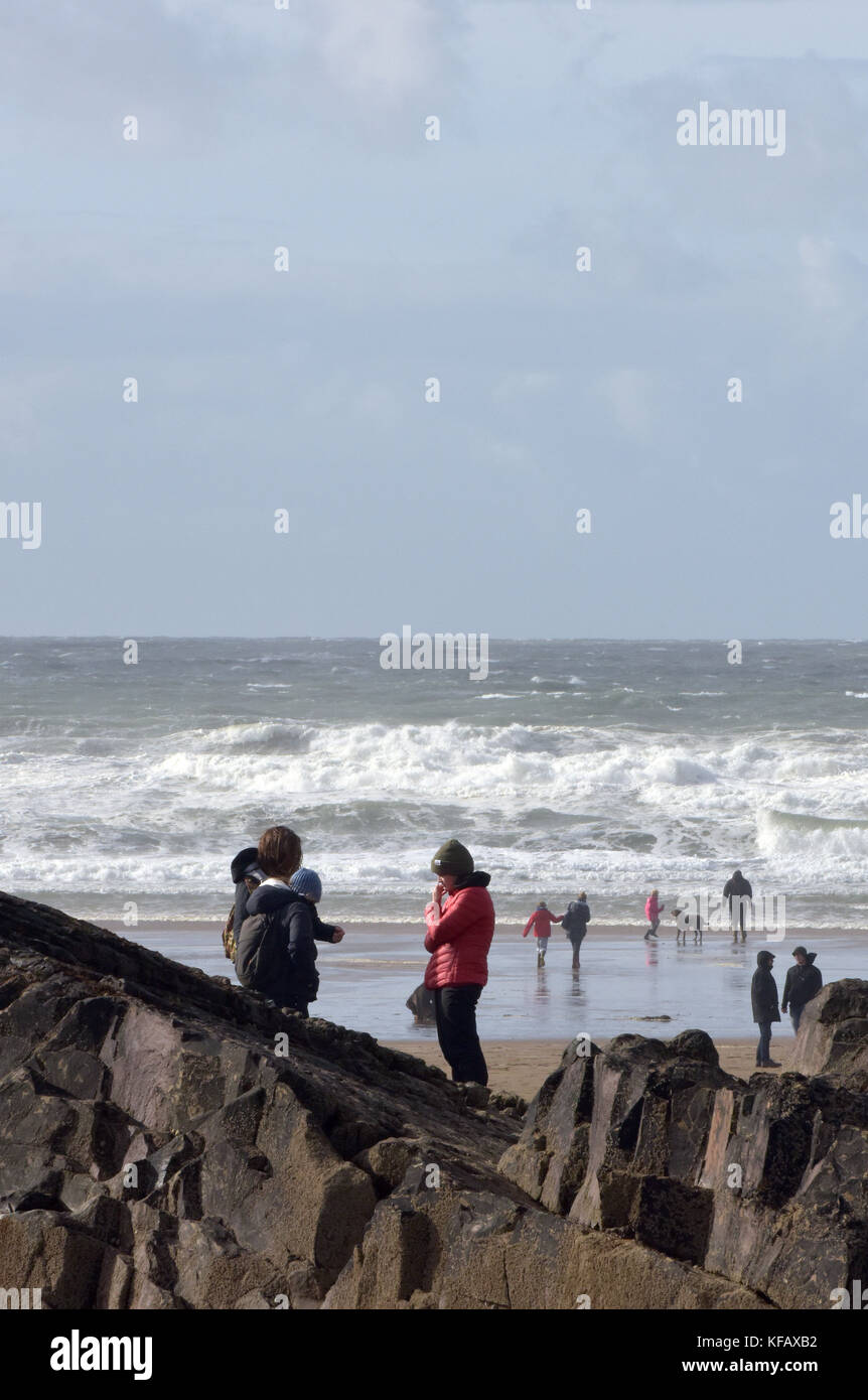 Families walking on the beach at Budd in cornwall or Devon on a windy ...