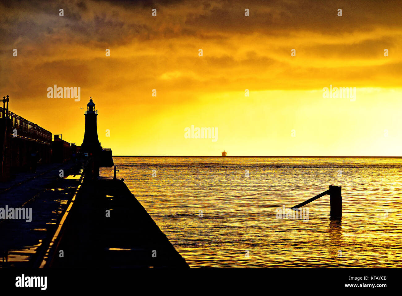 River Tyne Tynemouth North Pier at a golden sunrise with DFDS ferry on ...