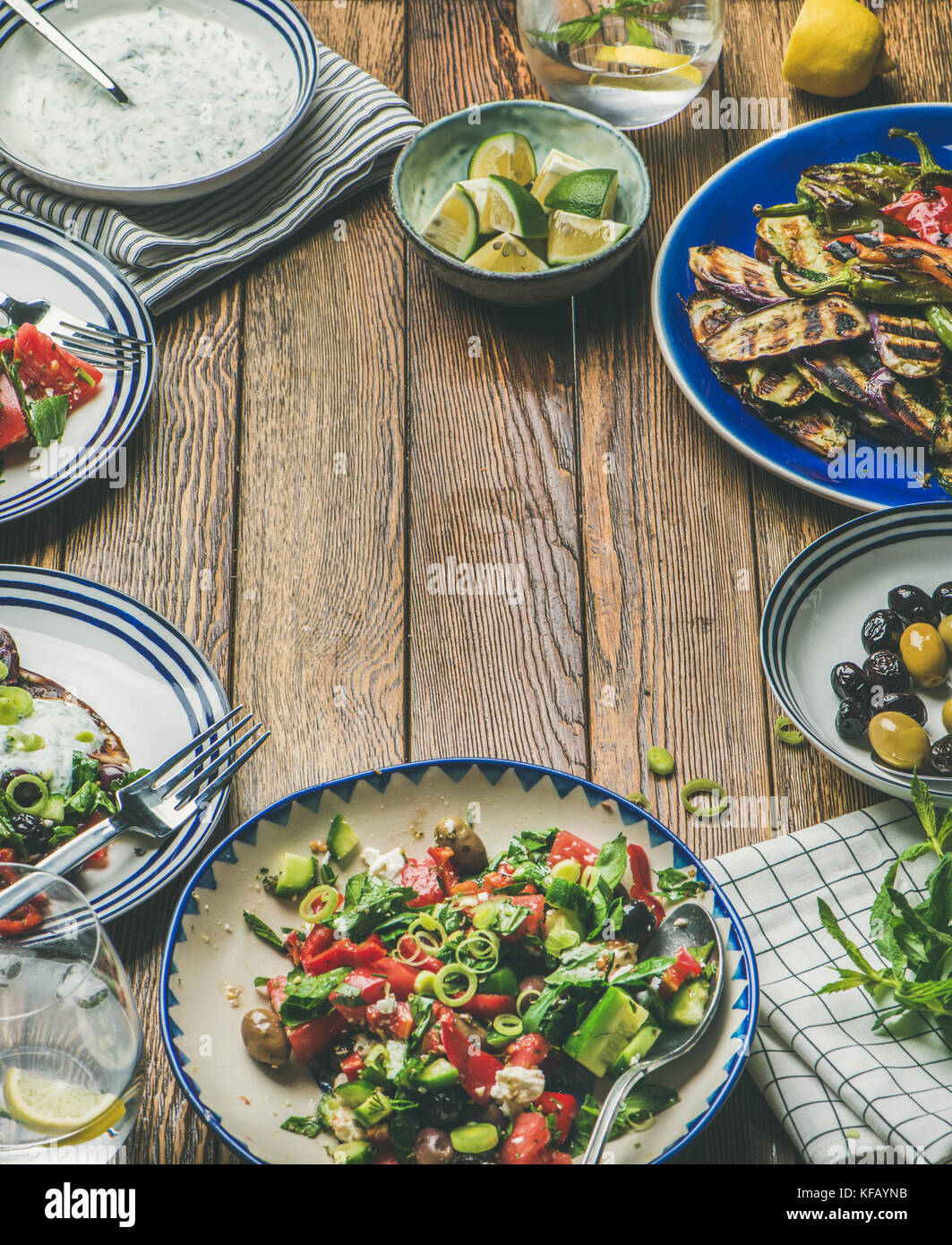 Healthy dinner table setting. Fresh salad, grilled vegetables with ...