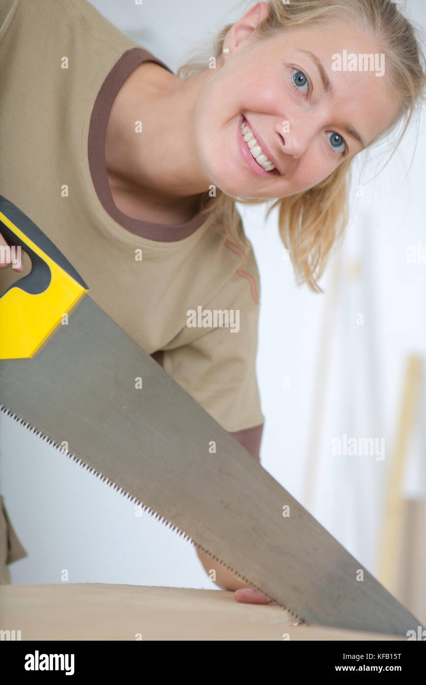young woman happily hand sawing Stock Photo - Alamy