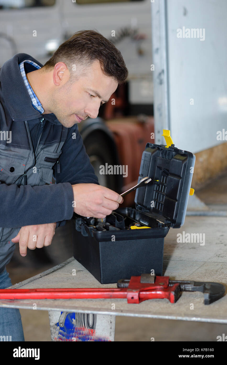 worker picking up a wrench in toolbox Stock Photo - Alamy