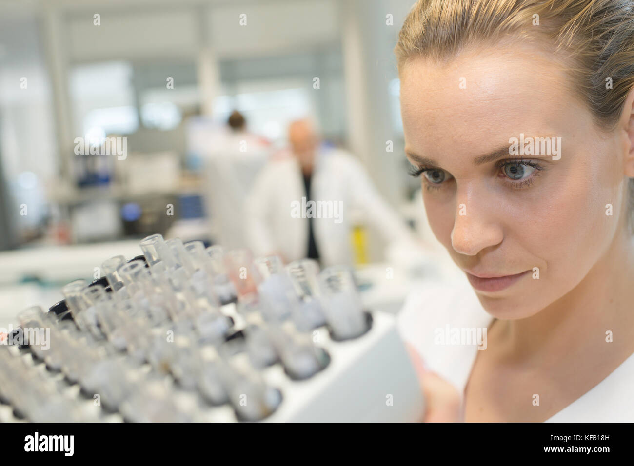 female scientist examining chemical sample in test tube in lab Stock ...