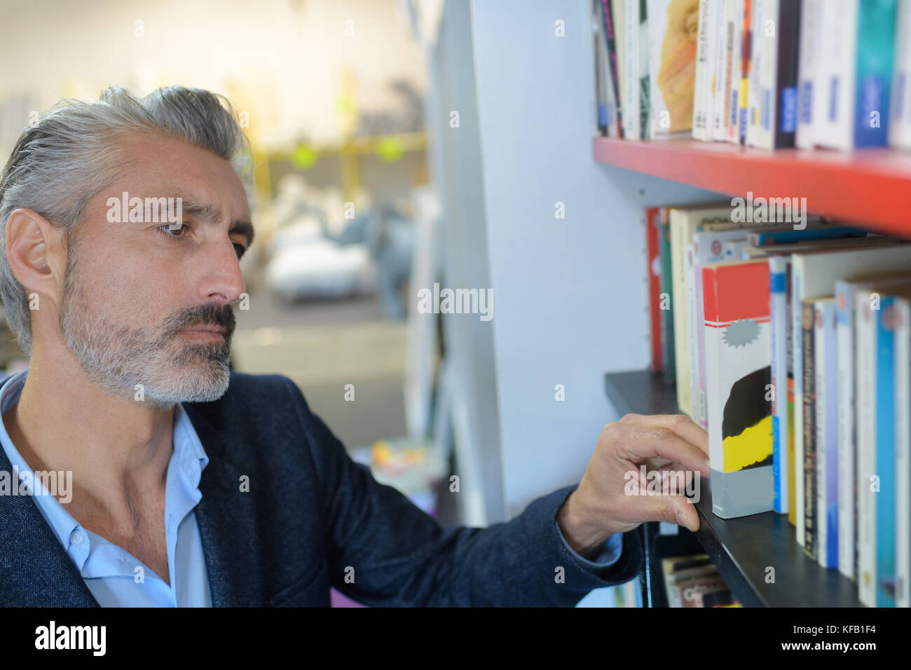 man in library choosing books Stock Photo - Alamy