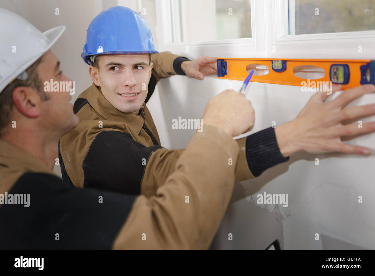 Young man learning to use spirit level Stock Photo - Alamy