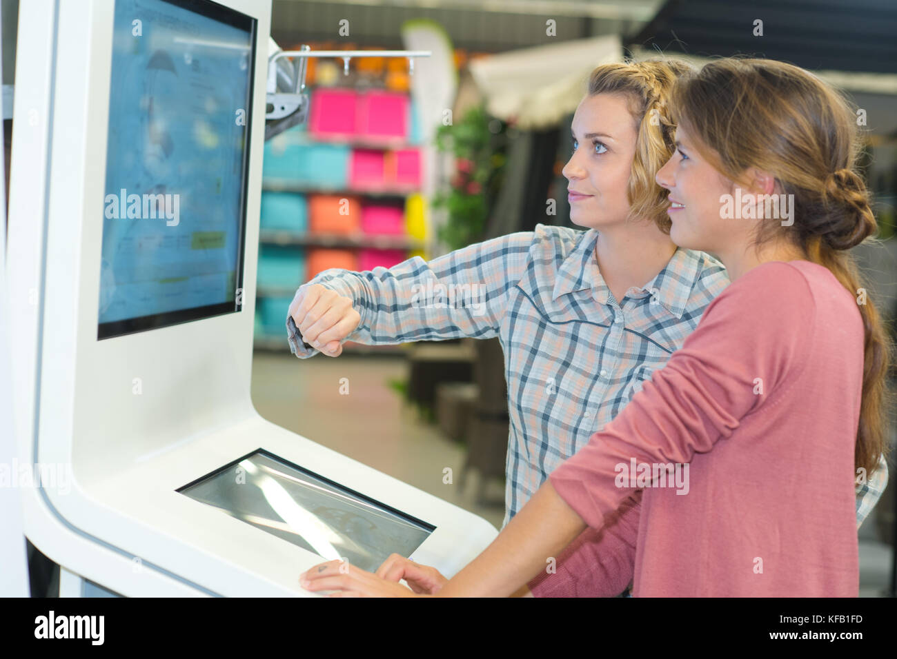 women checking their flight and tickets on a digital terminal Stock ...