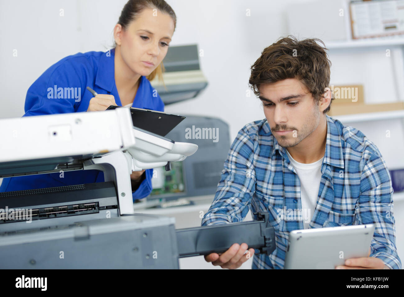 young apprentice is fixing a printer Stock Photo - Alamy
