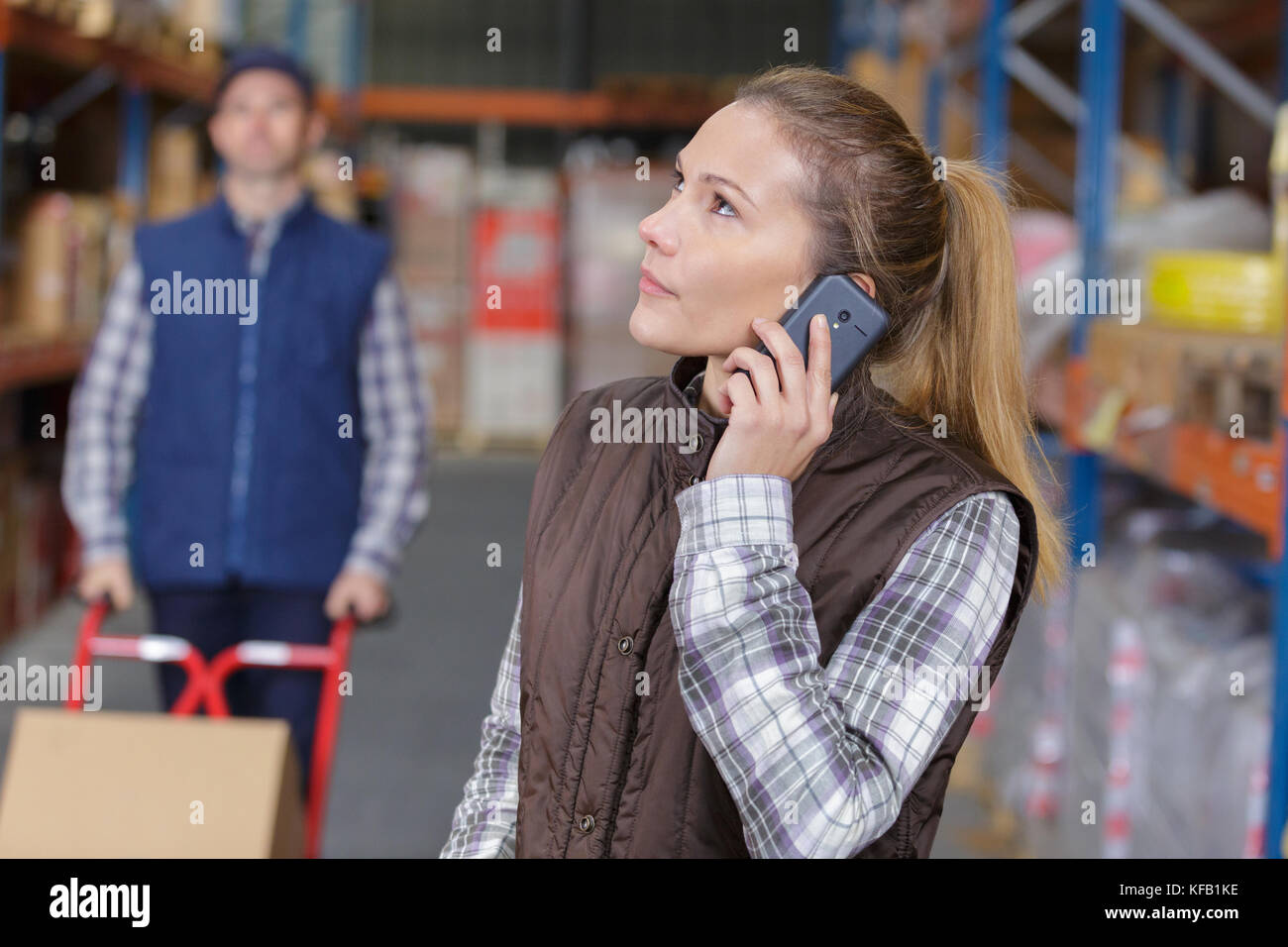 female worker using the phone in a warehouse Stock Photo - Alamy