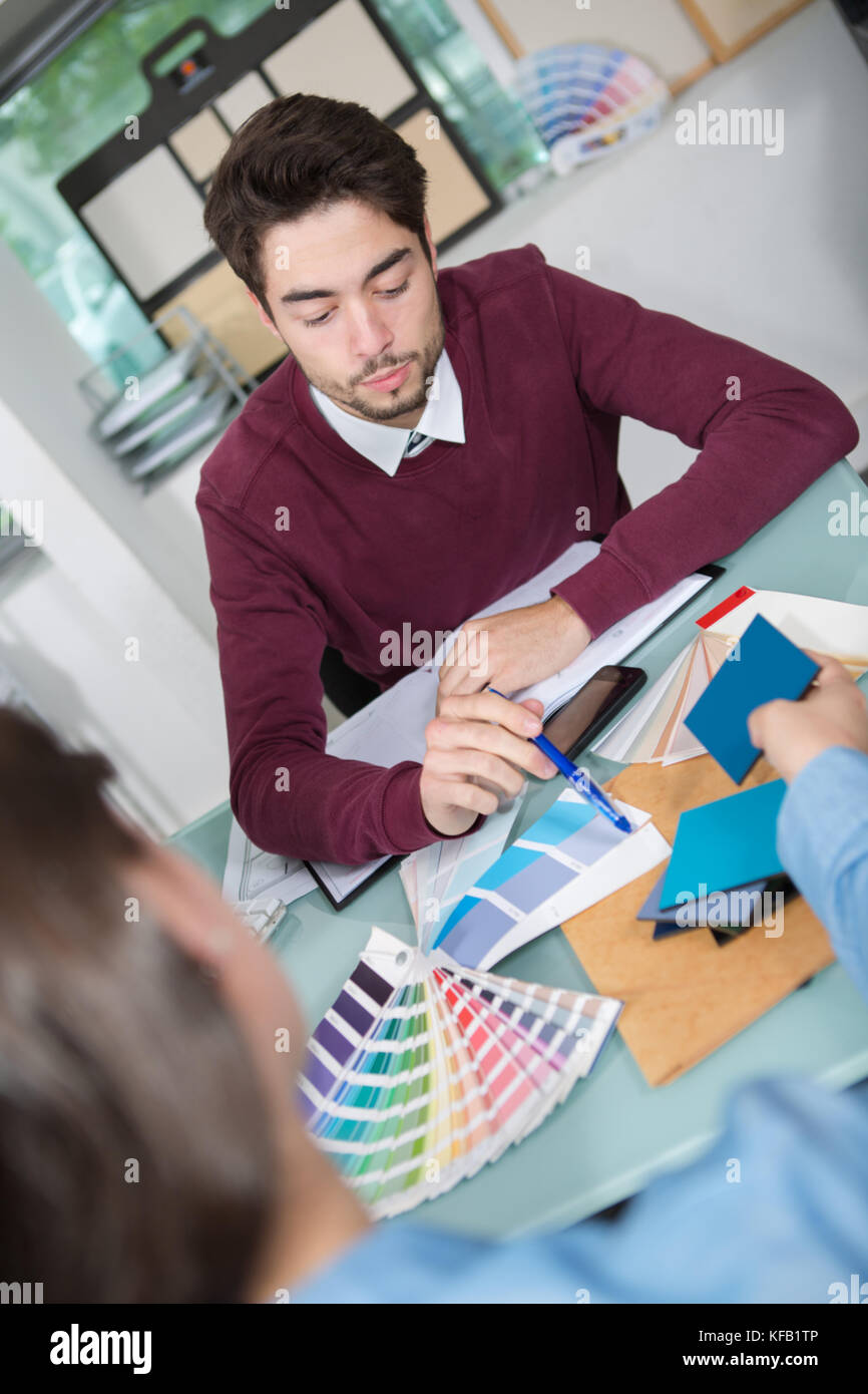 interior designer showing colour wheel to customer in his studio Stock ...