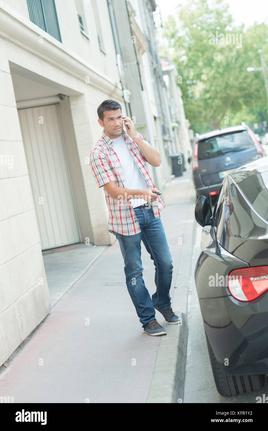 man on street approaching his car Stock Photo - Alamy
