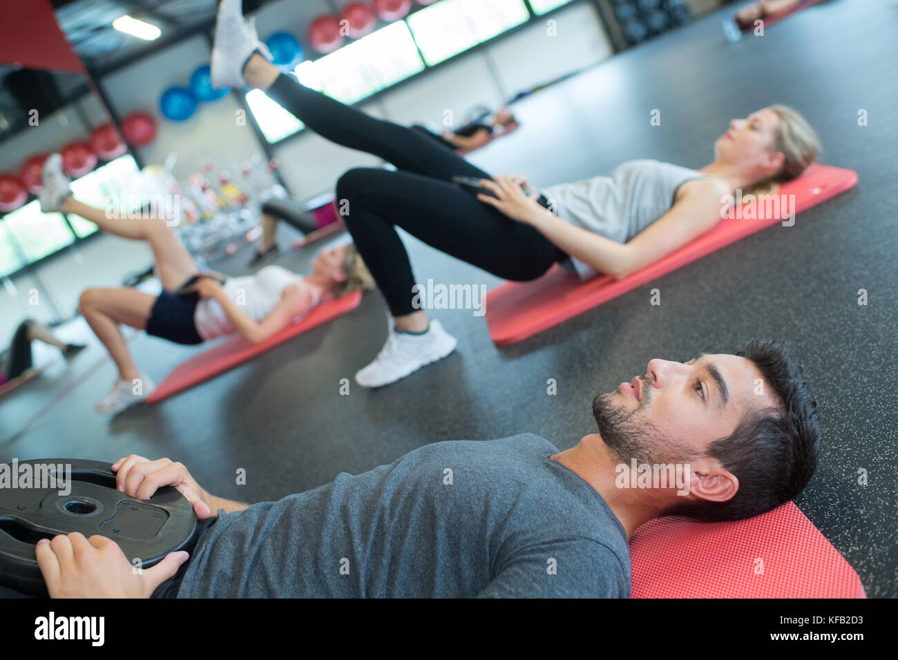 people doing physical exercises on floor at gym Stock Photo - Alamy