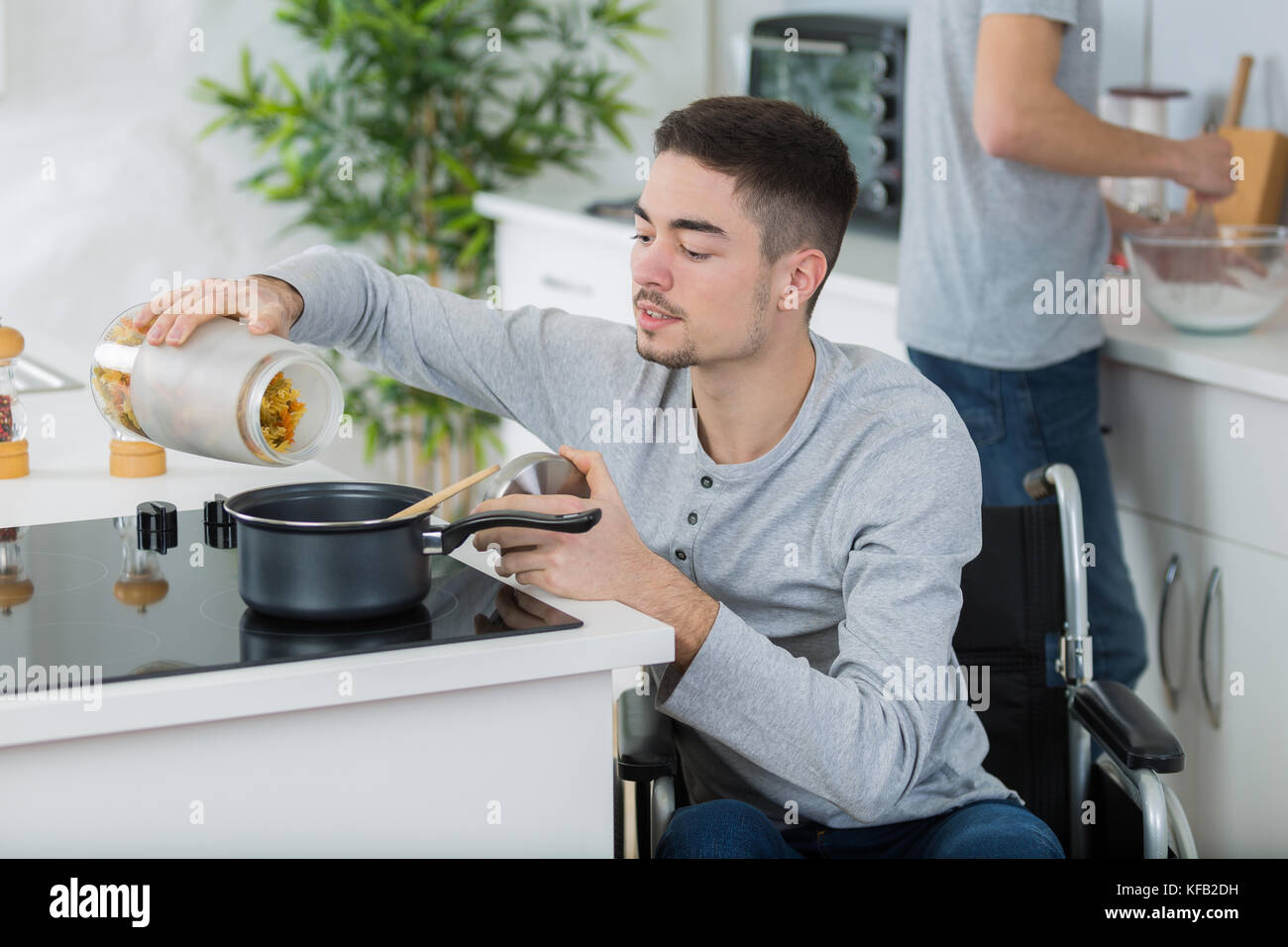 disabled young man in wheelchair cooking a meal in kitchen Stock Photo ...