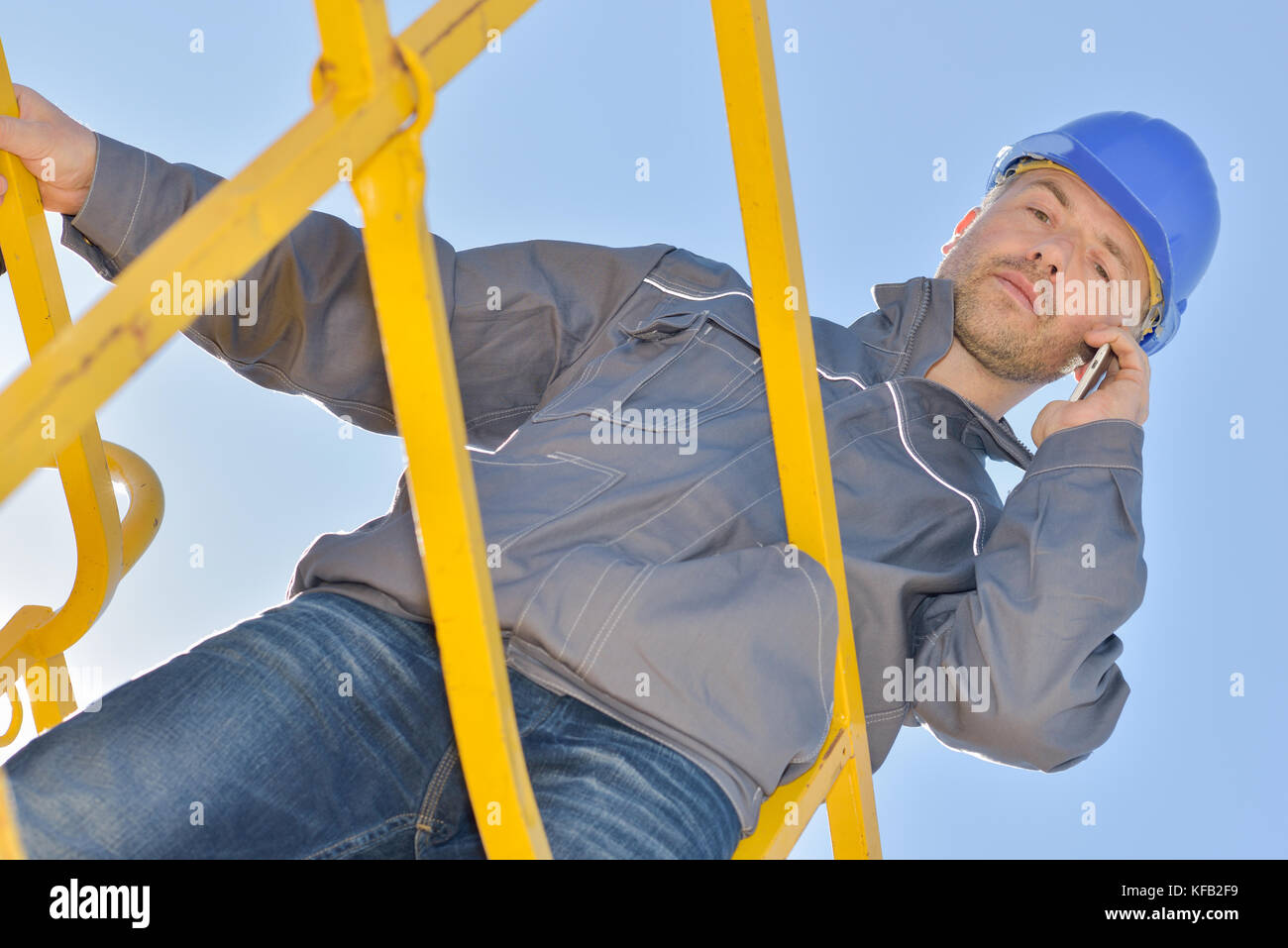 Man in elevated cherry picker using cellphone Stock Photo - Alamy