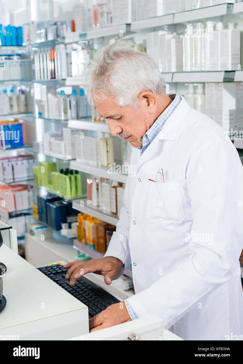 Pharmacist Using Computer Keyboard At Counter Stock Photo - Alamy