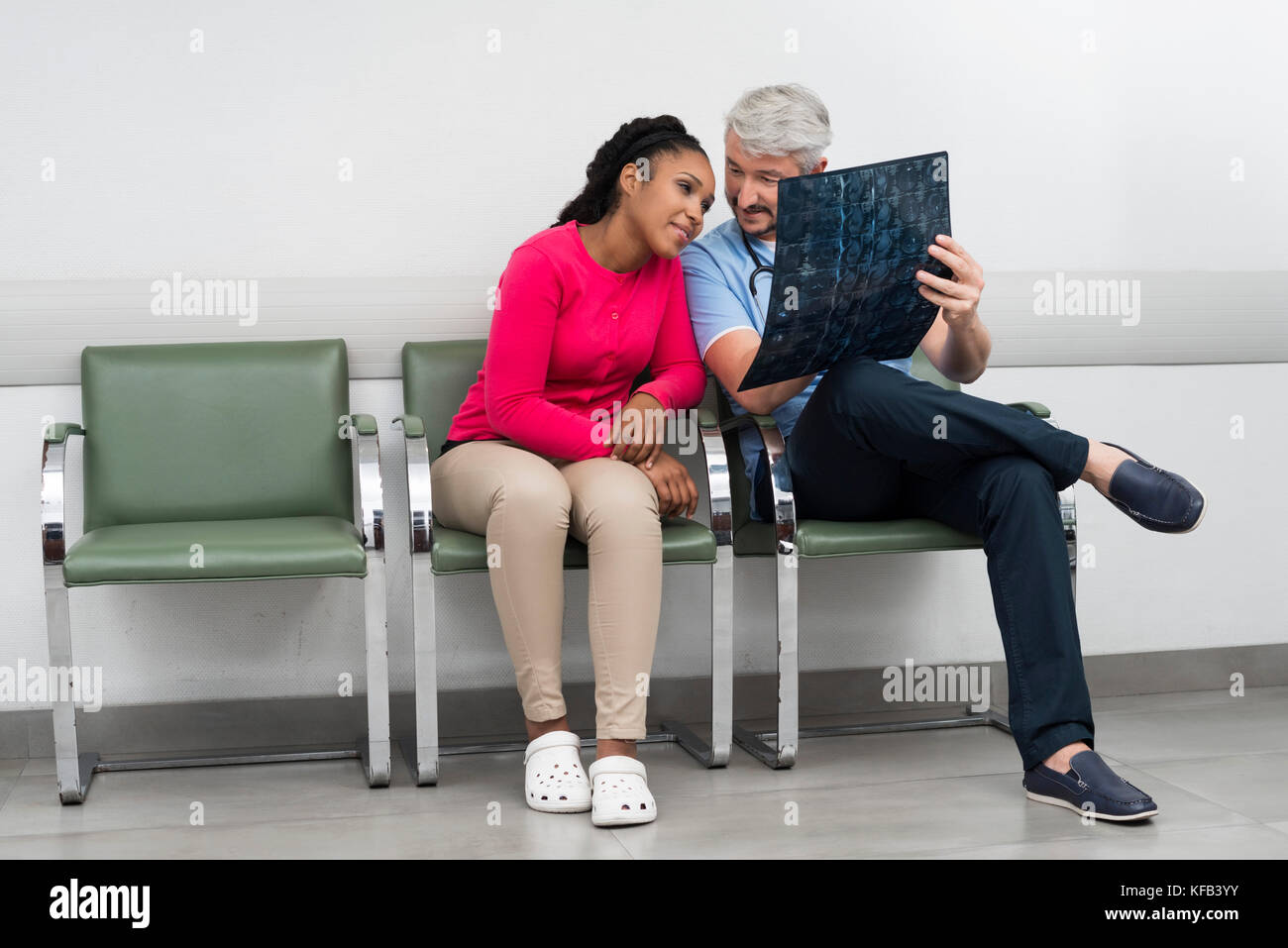 Doctor And Patient Looking At X-ray While Sitting On Chairs Stock Photo ...