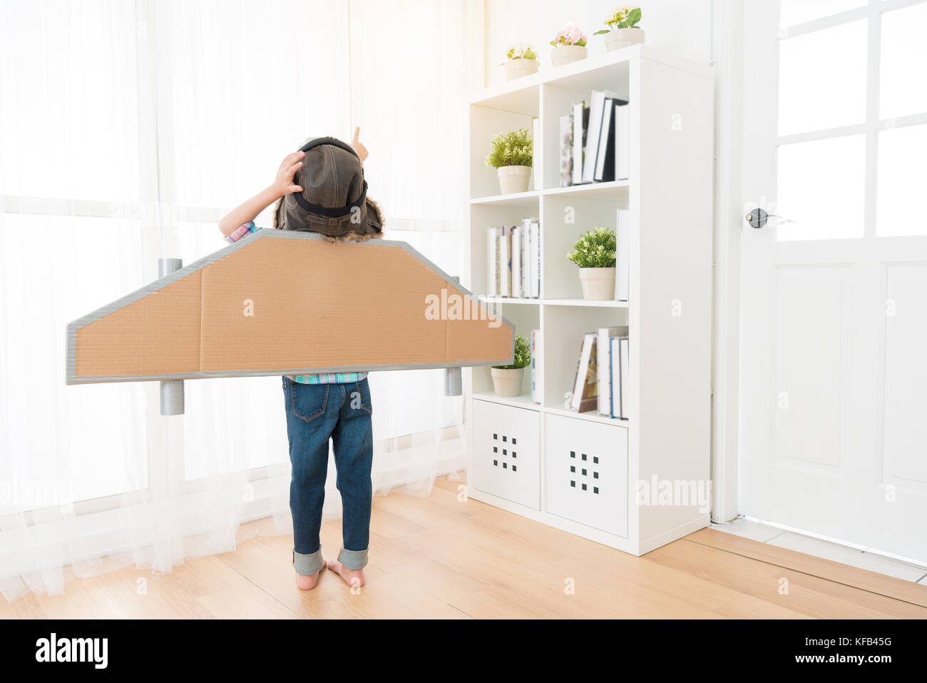 back view photo of little astronaut standing on wooden floor and ...