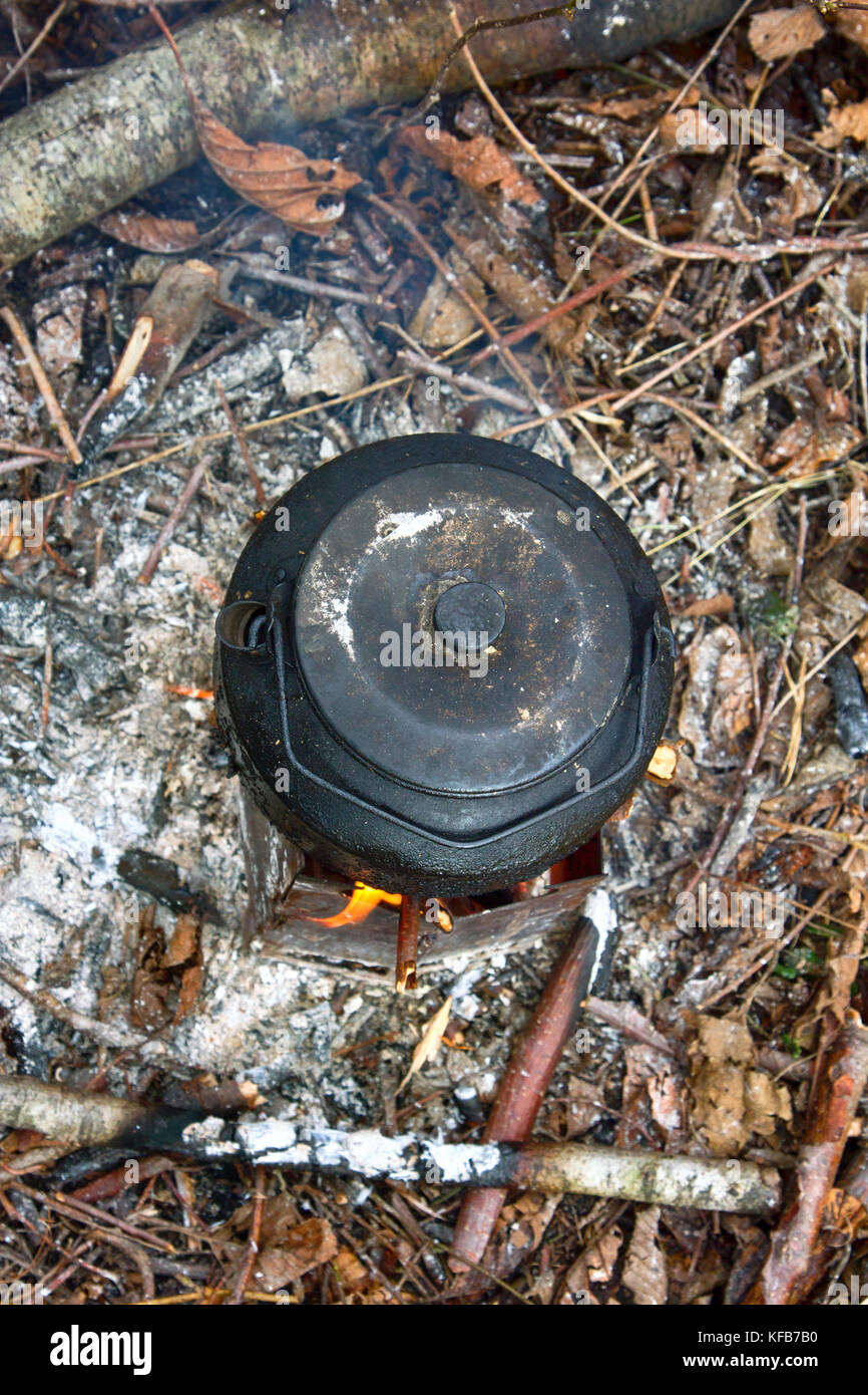 Cooking teapot over open fire at campsite Stock Photo - Alamy