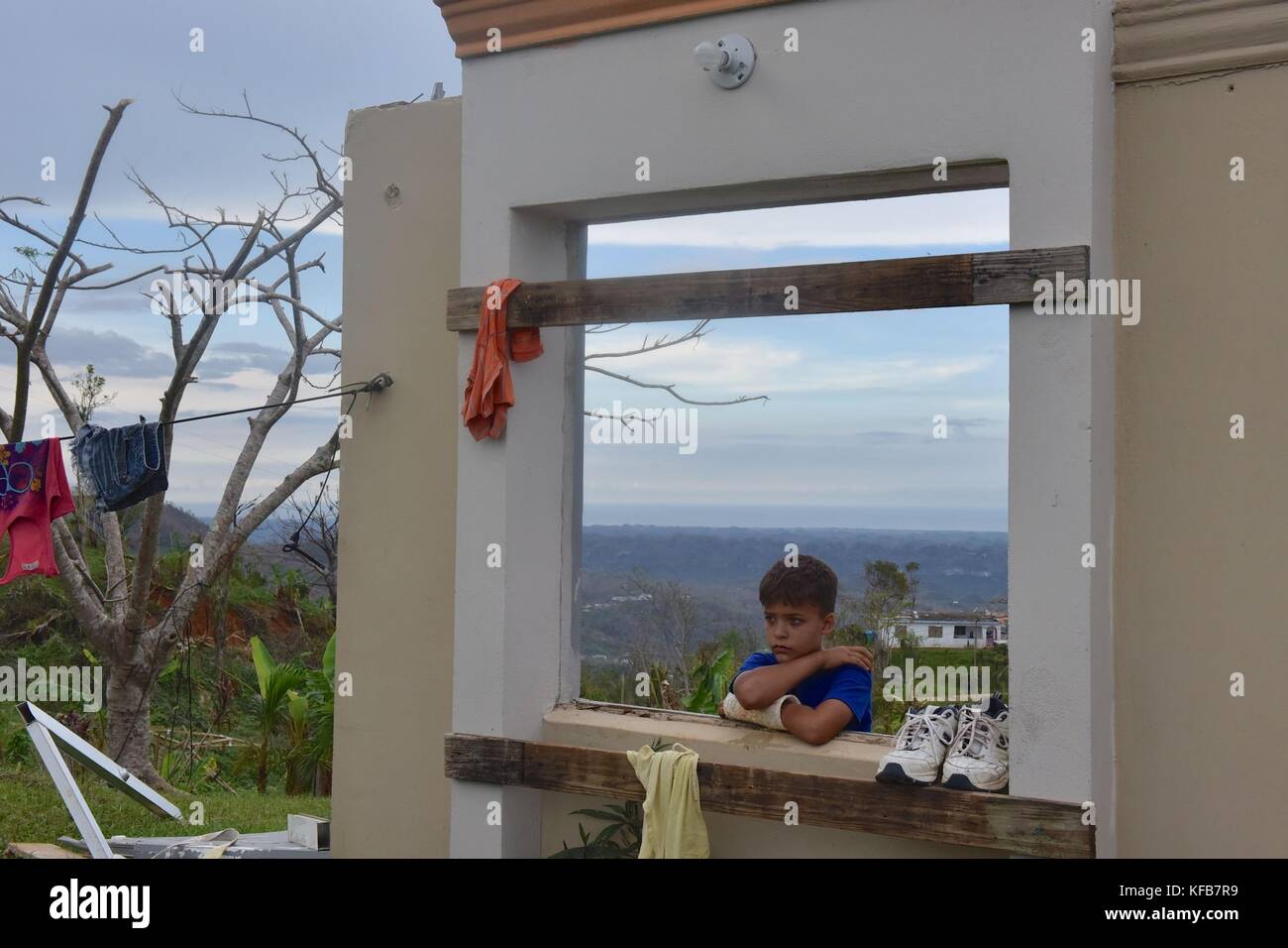A child stands in the window of a destroyed home in the aftermath of ...