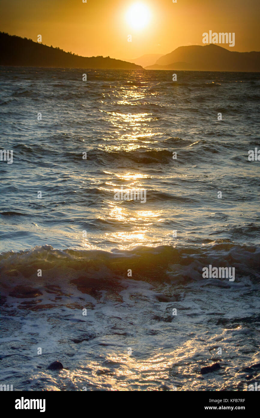 Stone beach, sun path, silhouettes of Islands, sunset. Romantic seaside ...