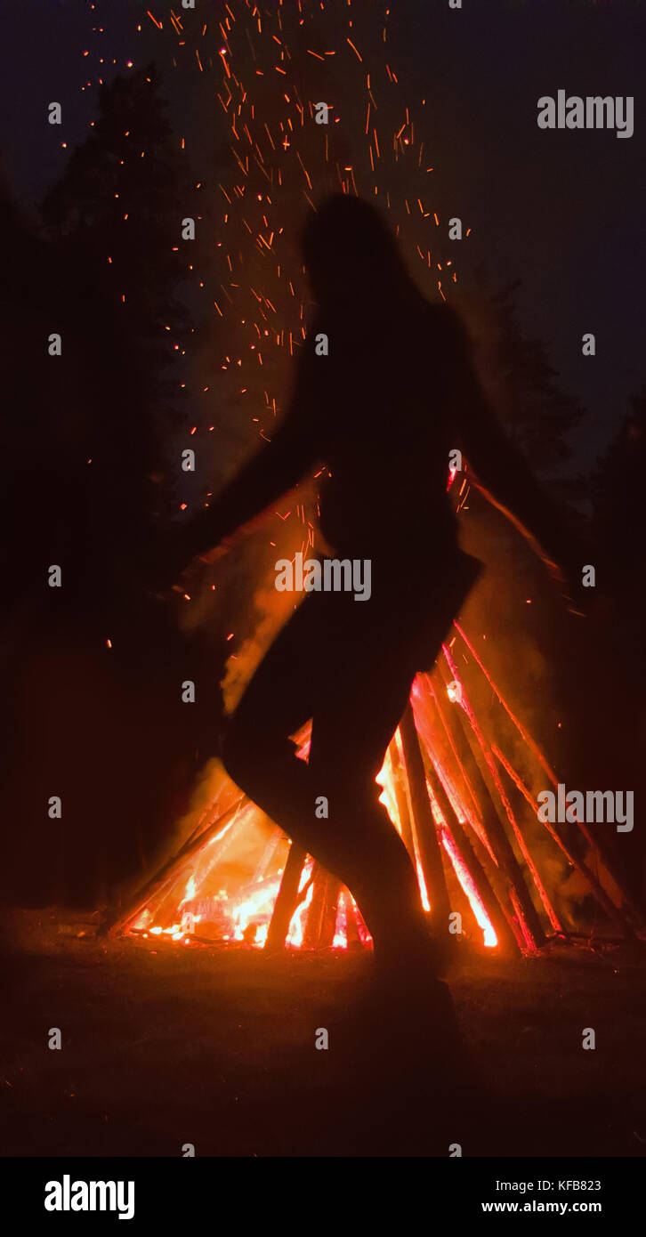 Huge fire at night and young people around. Pagan festival of Walpurgis ...