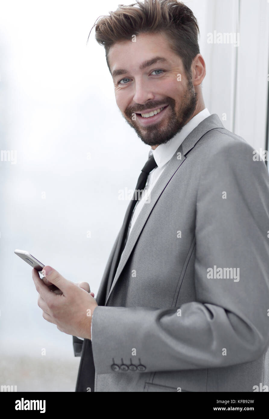 Stylish man in suit is reading information on phone Stock Photo - Alamy