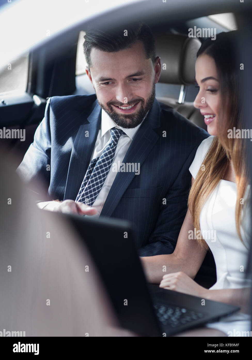 Smiling business people working in backseat of car Stock Photo - Alamy