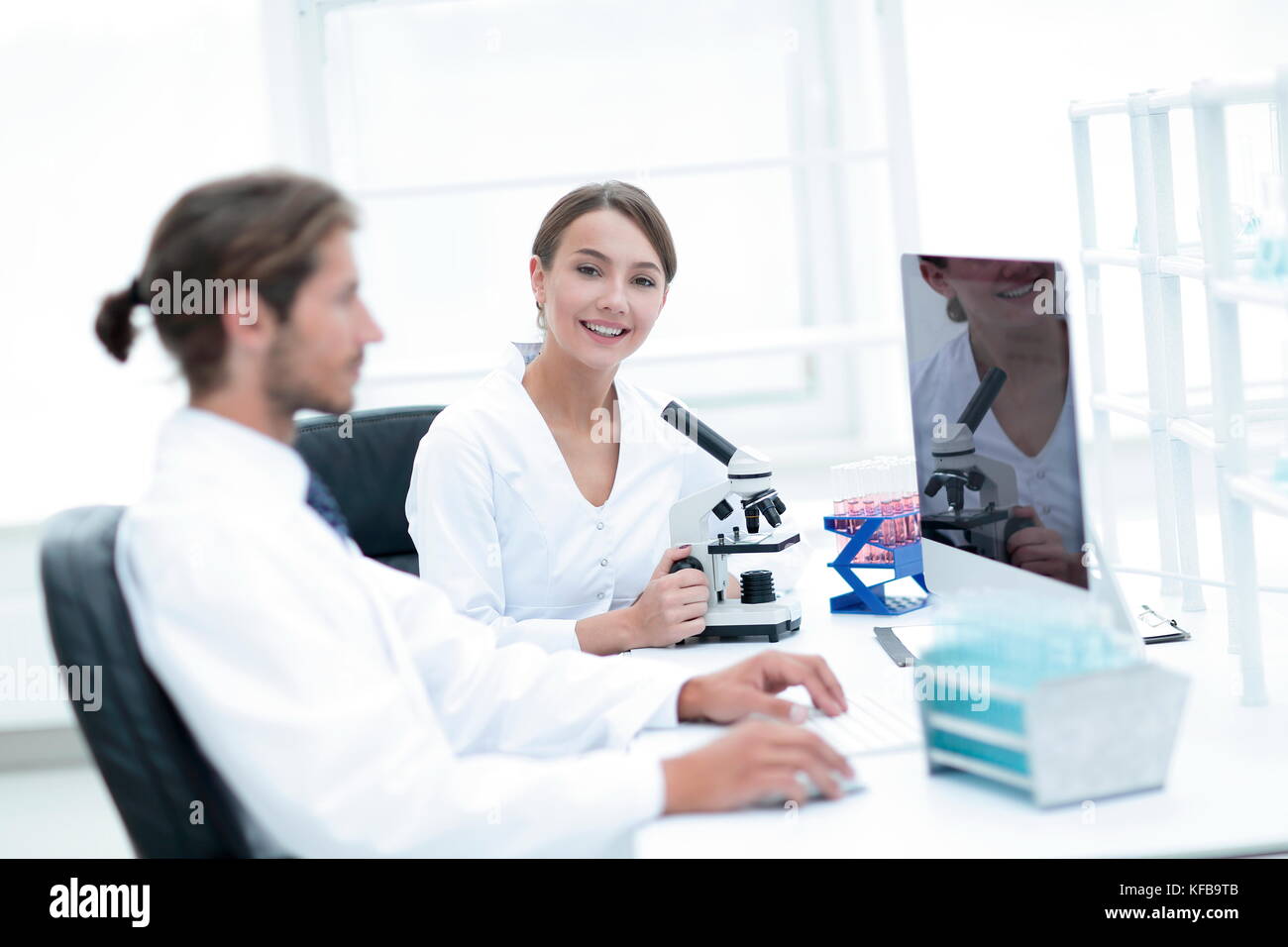 Lab expert working on a test using microscope Stock Photo - Alamy