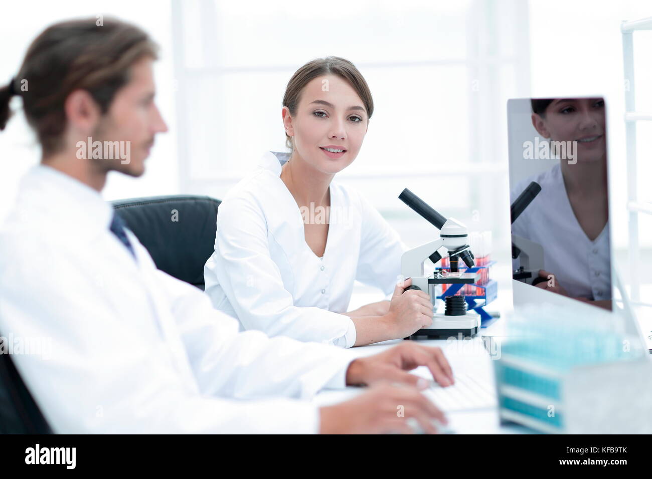 Lab expert working on a test using microscope Stock Photo - Alamy