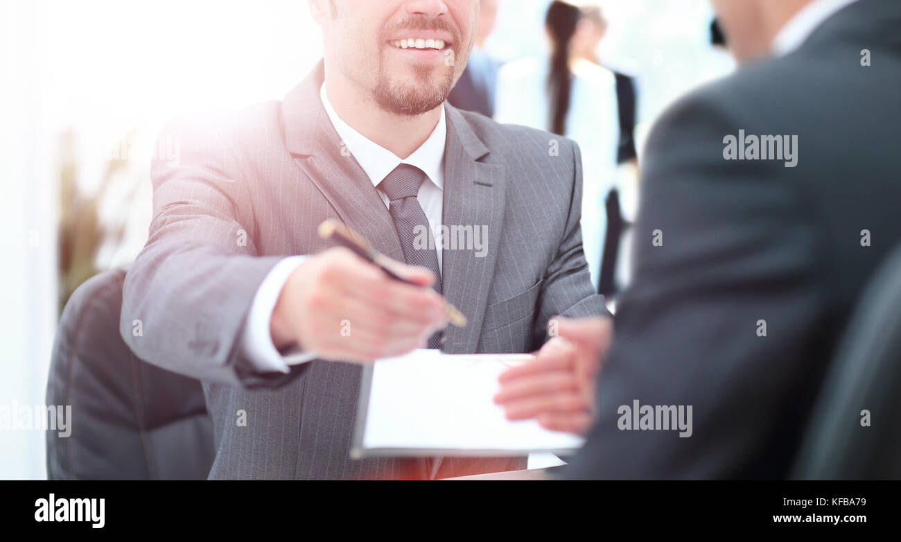 Businessman giving a pen his customer Stock Photo - Alamy