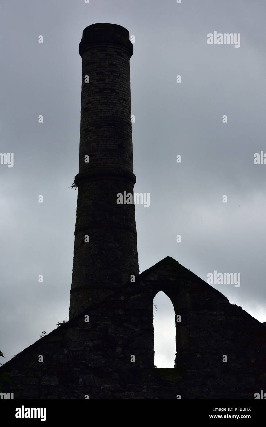 A silhouette of a Cornish tin mine engine house against a stormy cloudy ...